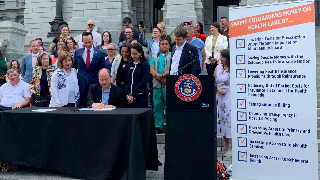 Polis signs ‘Colorado Option’ health insurance bill into law on Capitol ...