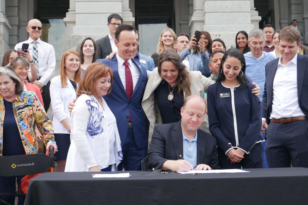 Polis signs ‘Colorado Option’ health insurance bill into law on Capitol ...